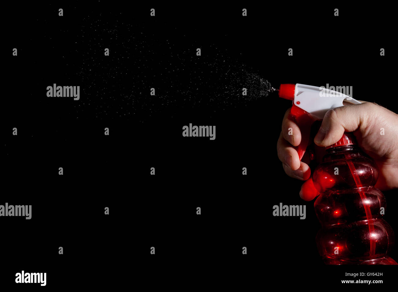 a human hand with a spray gun sprays water on a dark background Stock ...