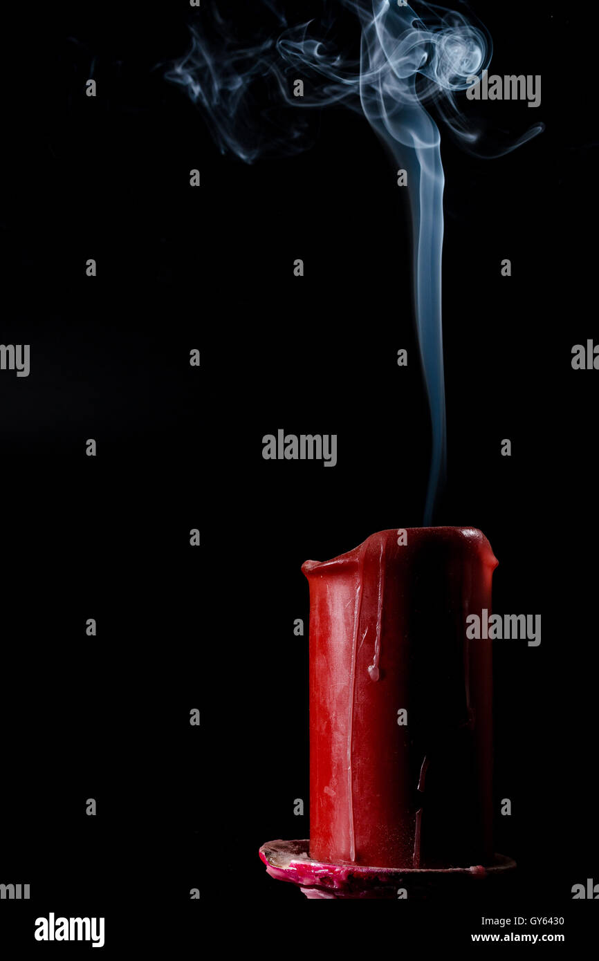 extinguished candle of red color on a dark background Stock Photo - Alamy