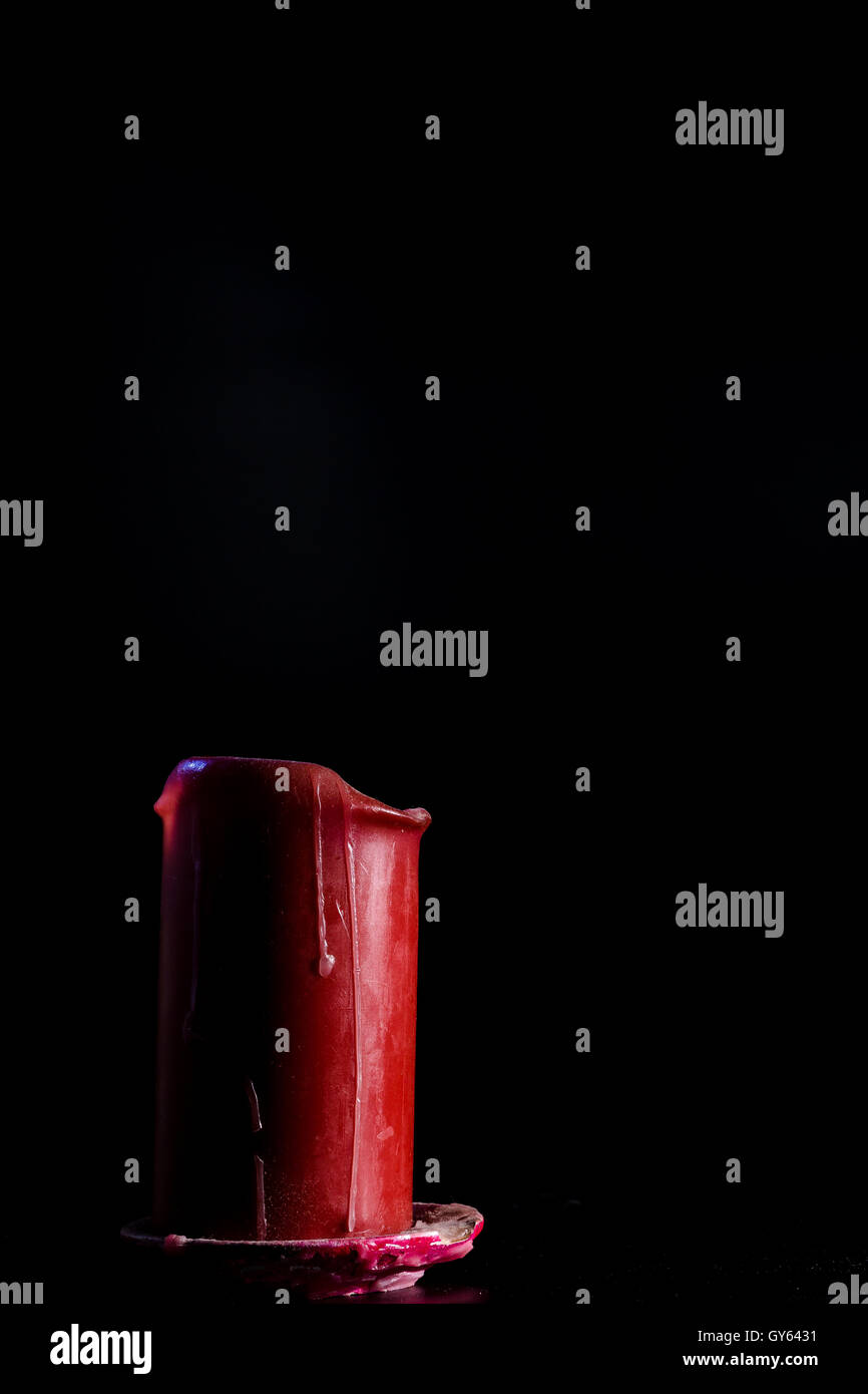 red candle is extinguished in the dark Stock Photo - Alamy