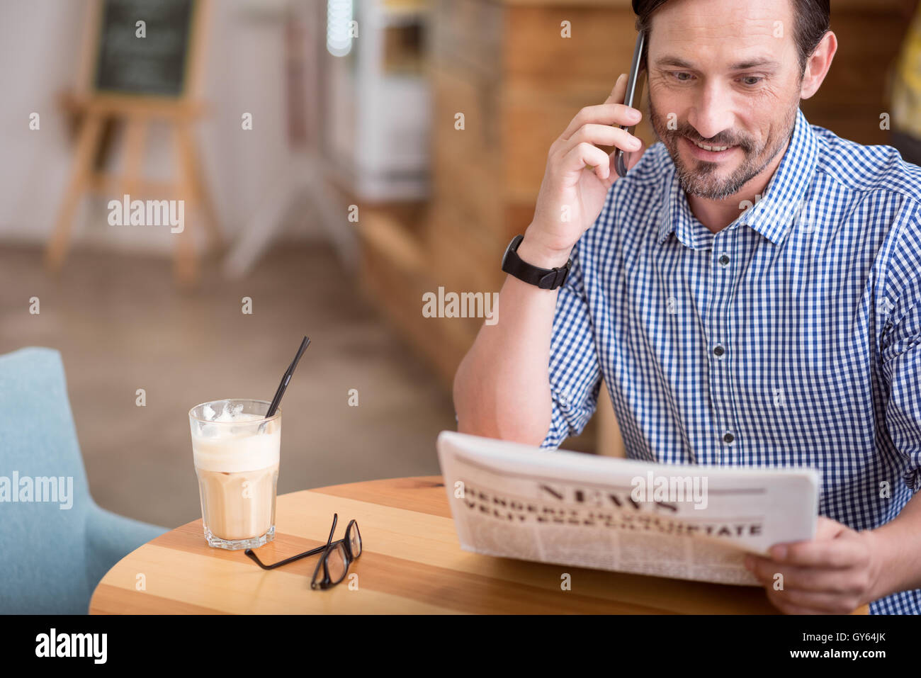 Handsome man reading a newspaper Stock Photo - Alamy
