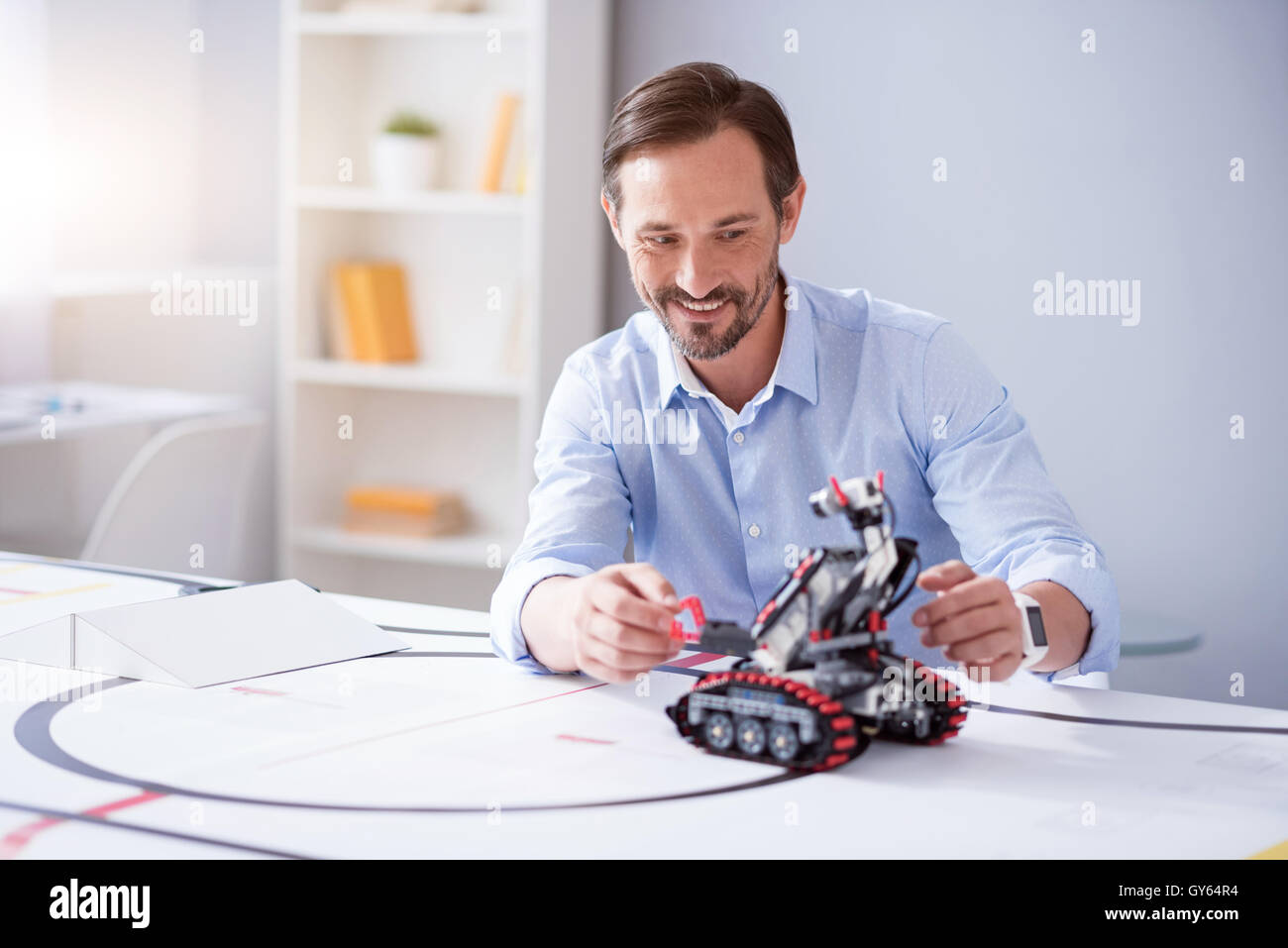 Happy man playing with a robot Stock Photo - Alamy