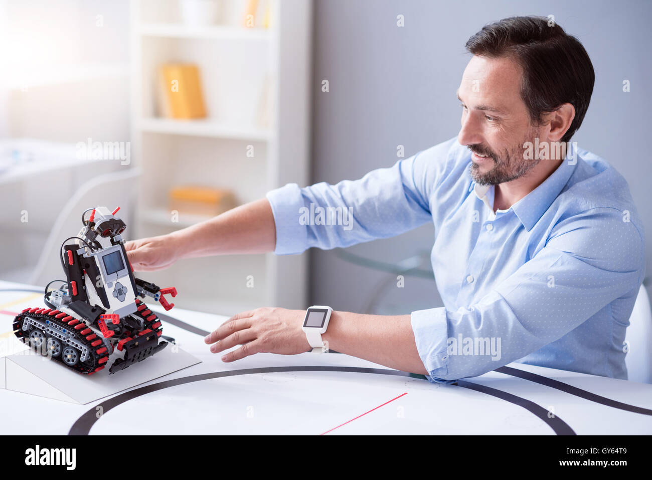Happy and satisfied engineer testing robot in his science lab Stock ...