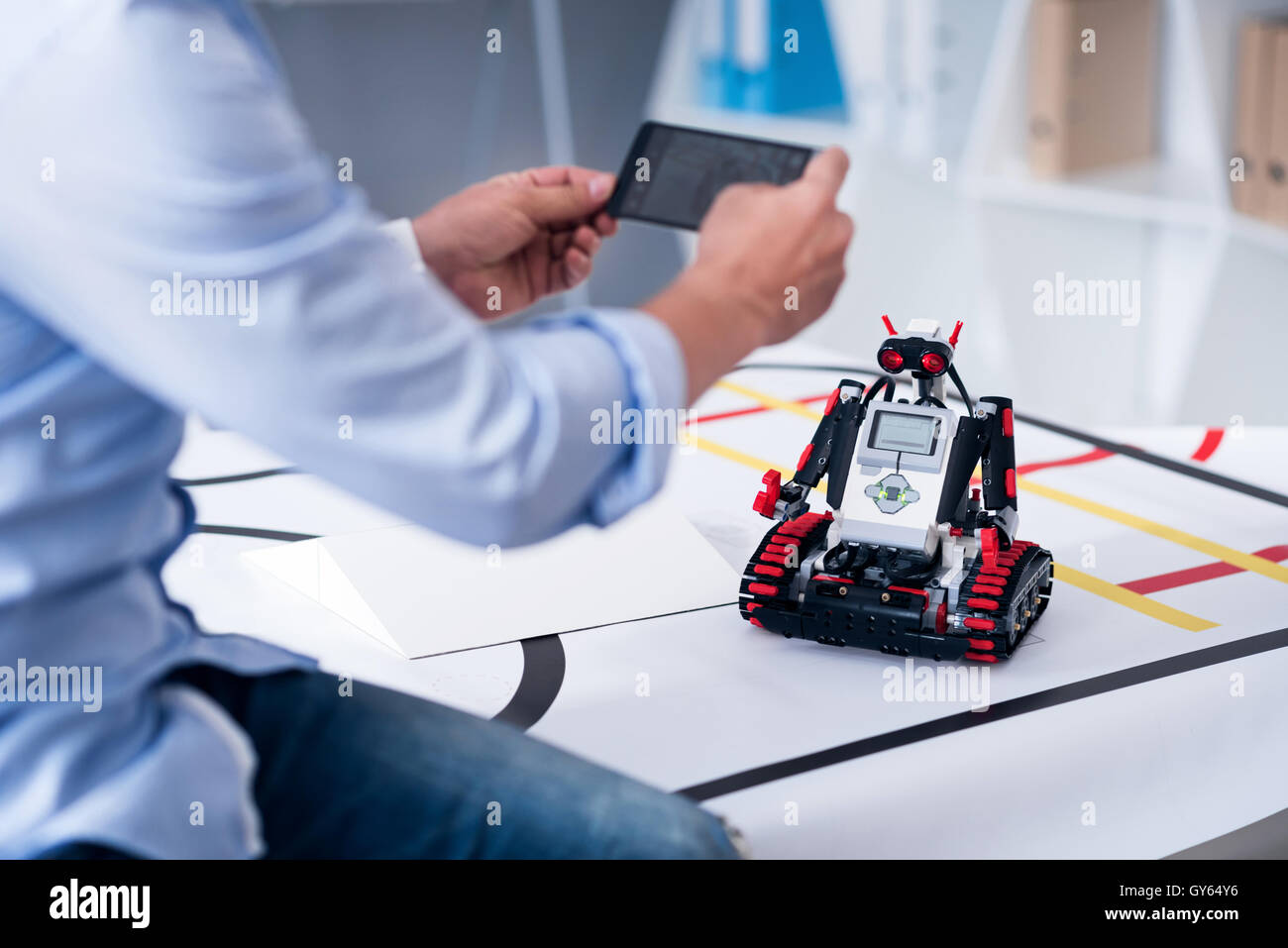 Male taking pictures of a droid with mobile phone Stock Photo - Alamy