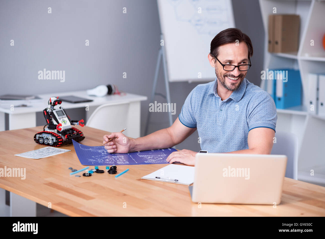 Positive engineer sitting at the table Stock Photo - Alamy