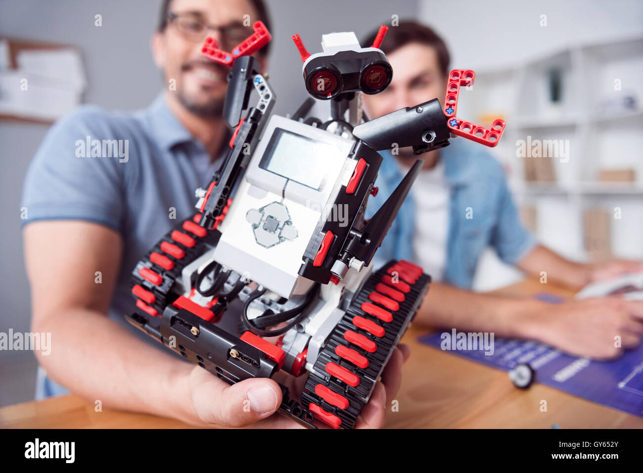 Positive engineer holding robot Stock Photo - Alamy