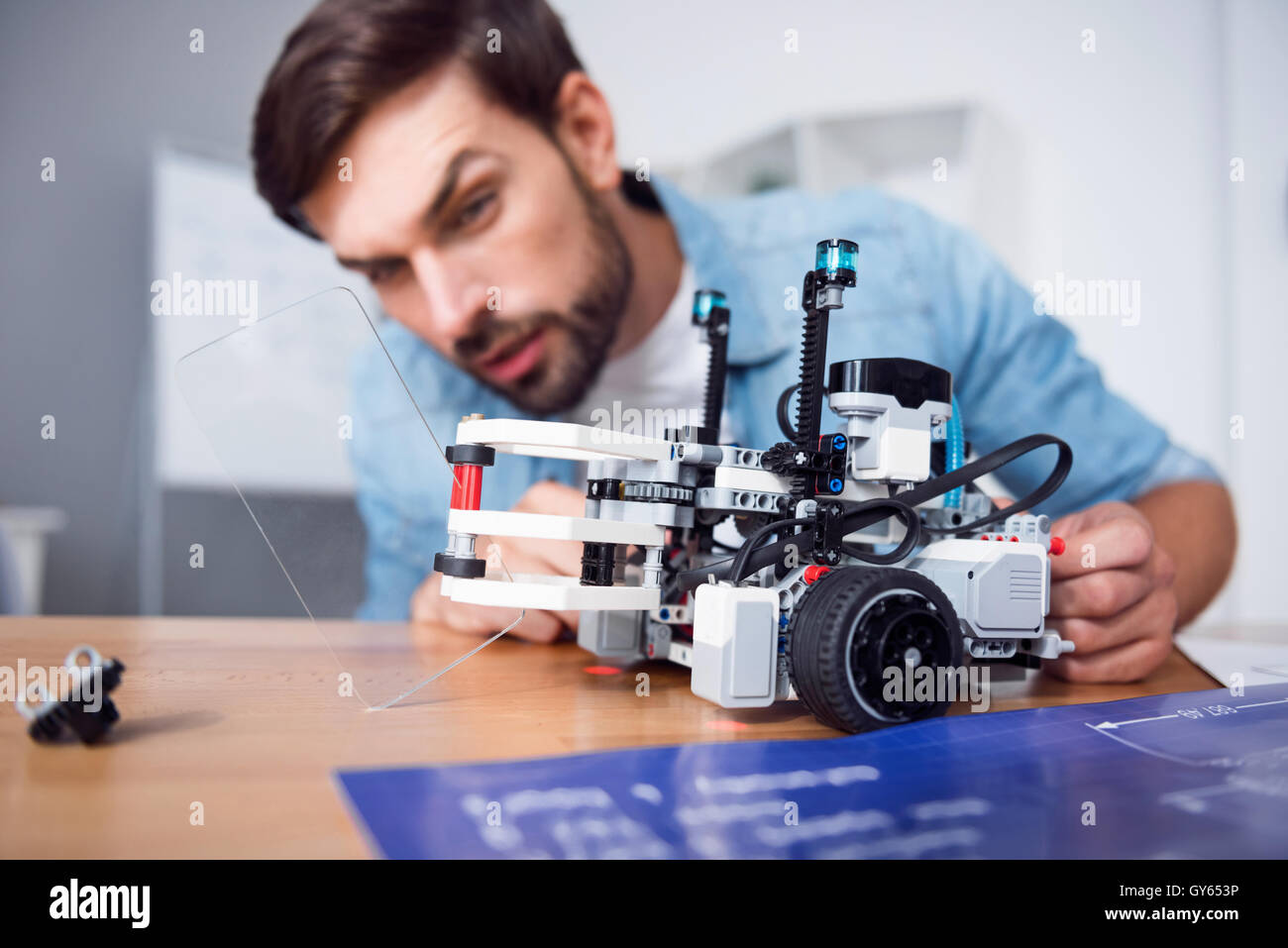Pleasant professional man testing robot Stock Photo - Alamy