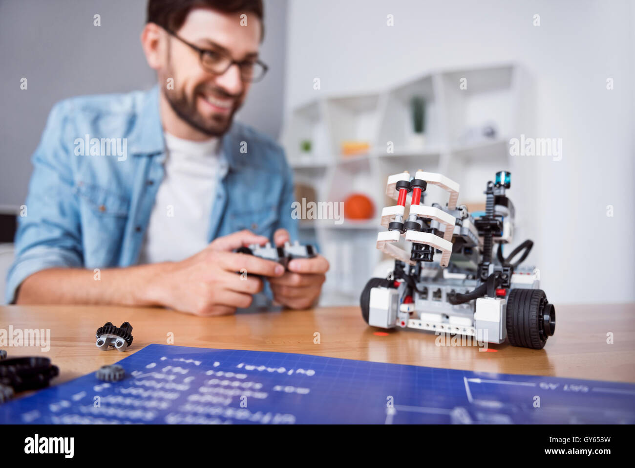 Cheerful man testing robot Stock Photo - Alamy