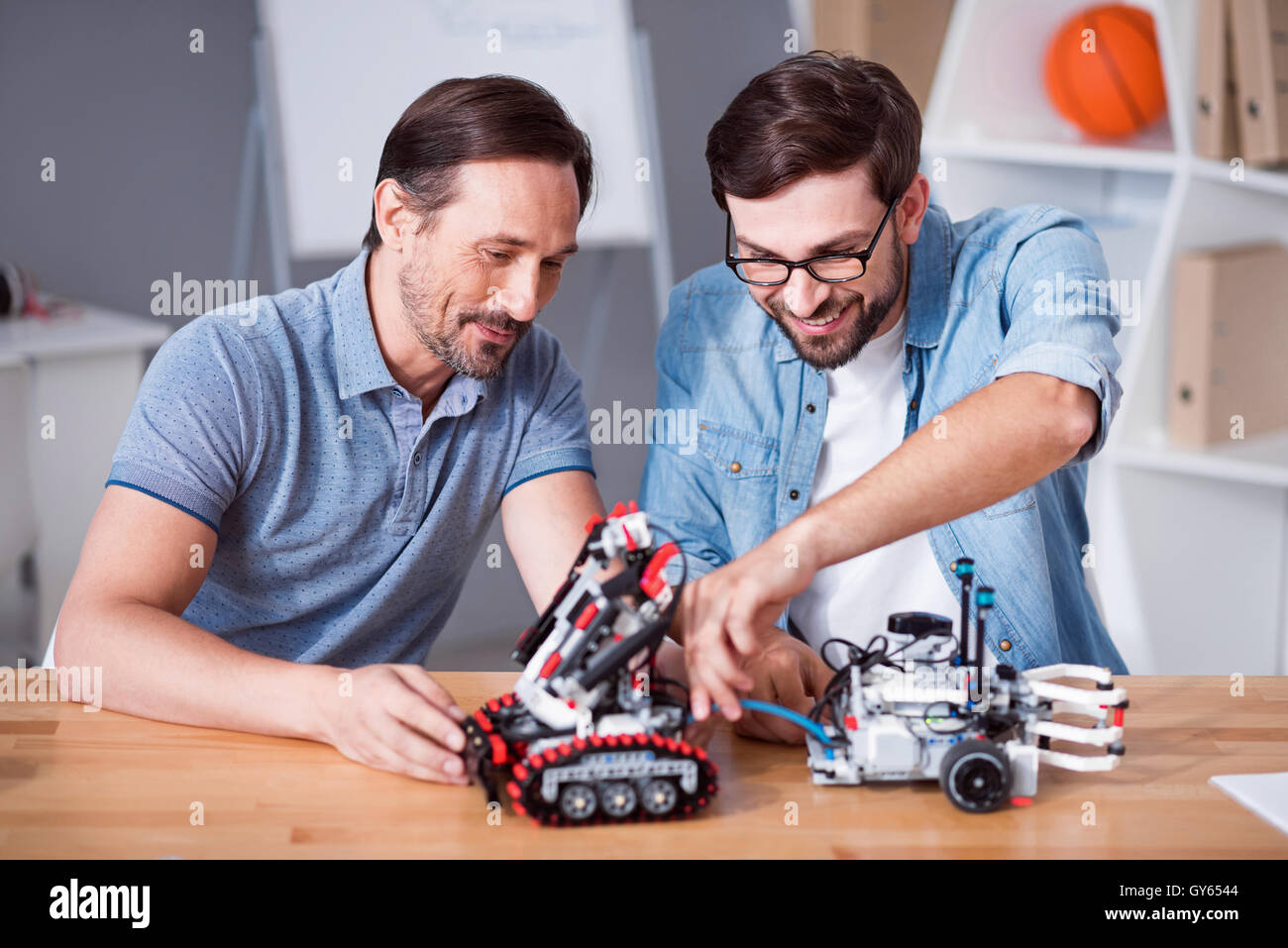 Delighted colleagues testing robot Stock Photo - Alamy