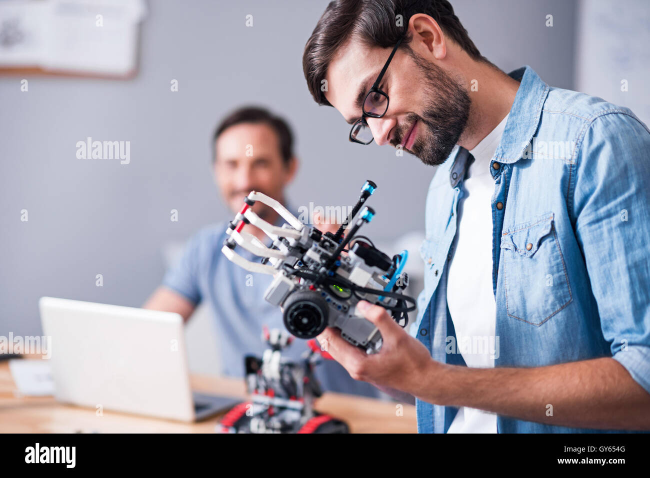 Cheerful man testing robot Stock Photo - Alamy