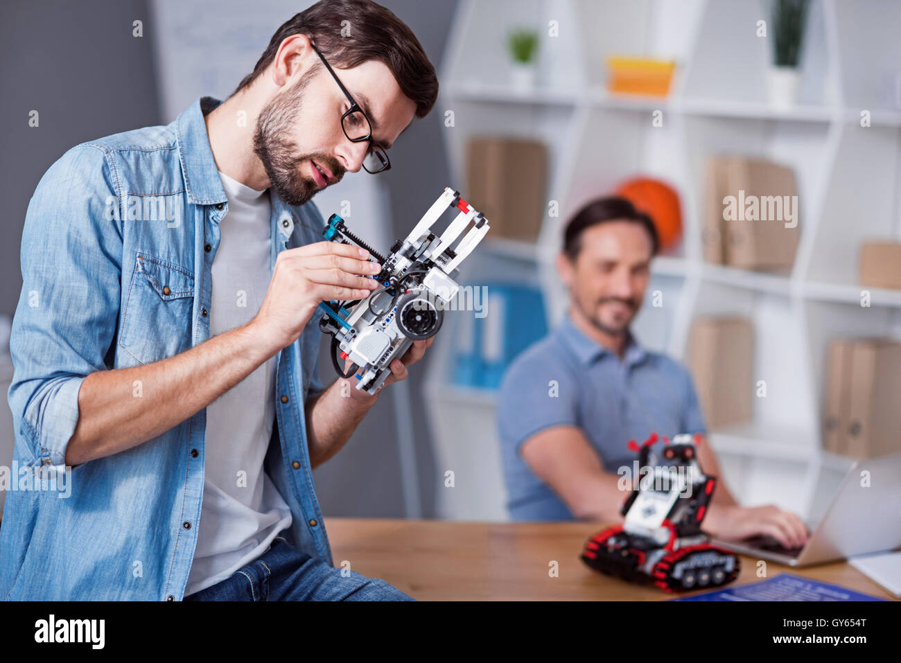 Concentrated man using robot Stock Photo - Alamy