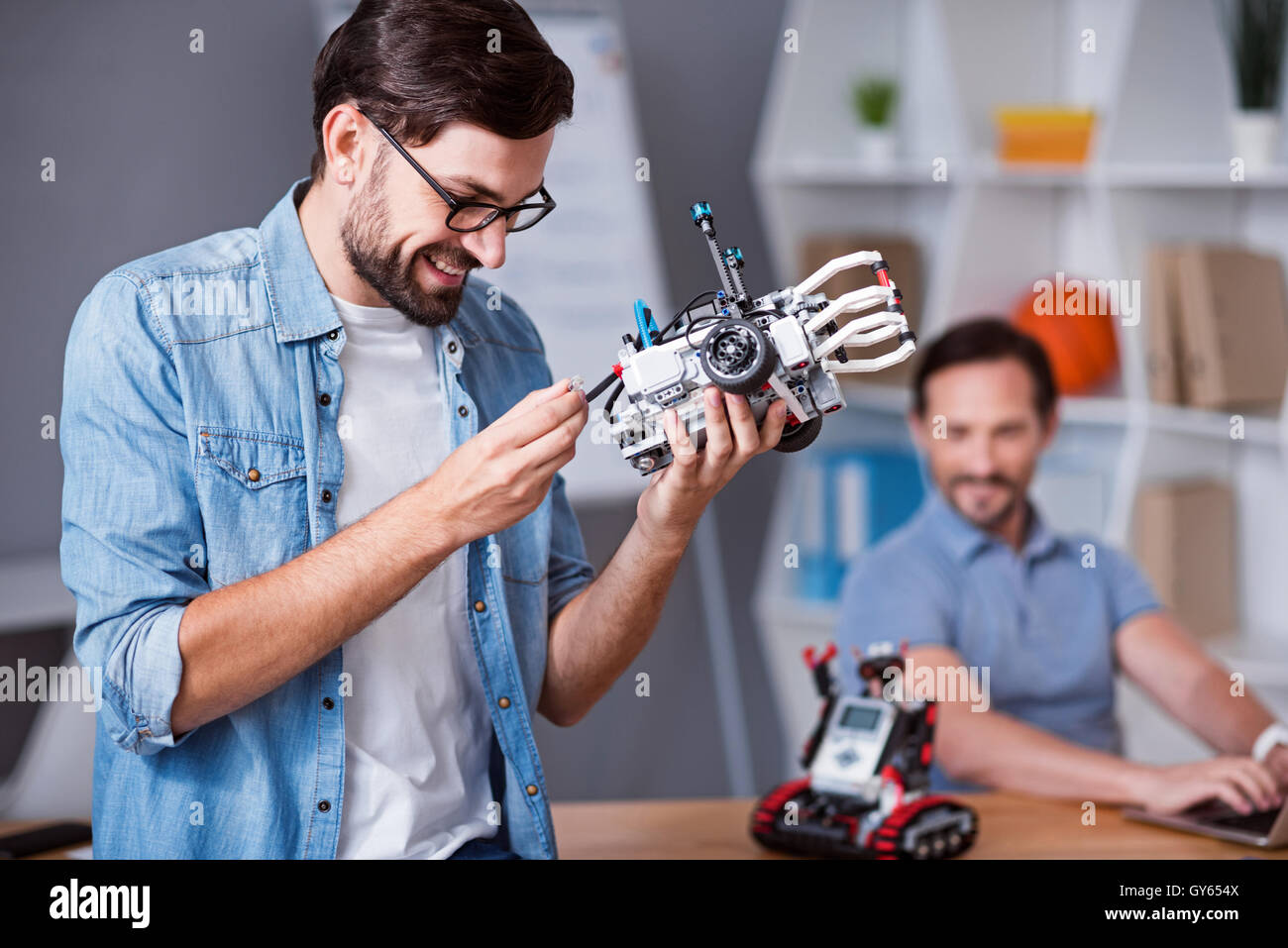 Cheerful man using robot Stock Photo - Alamy