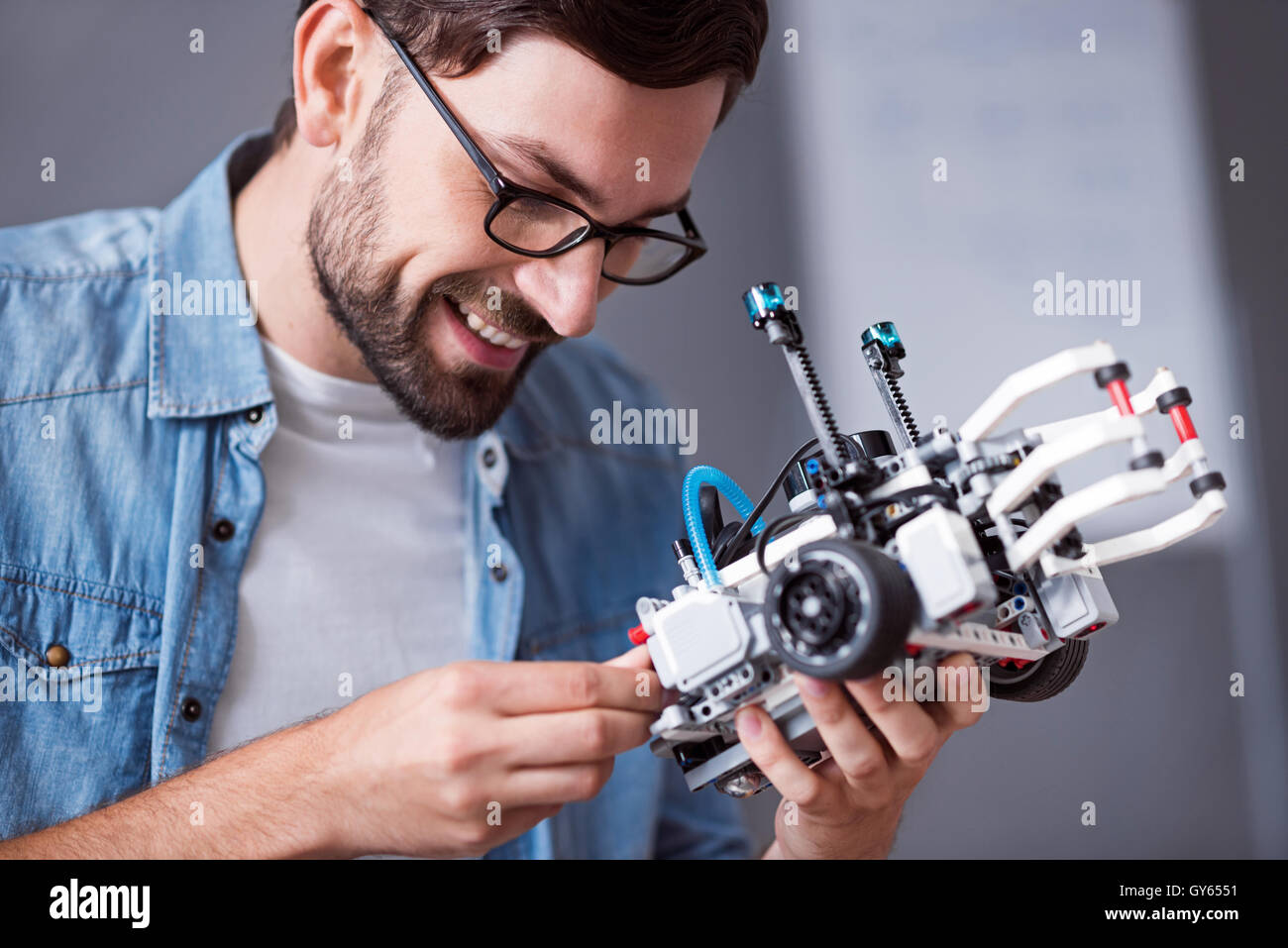 Cheerful man holding robot Stock Photo - Alamy