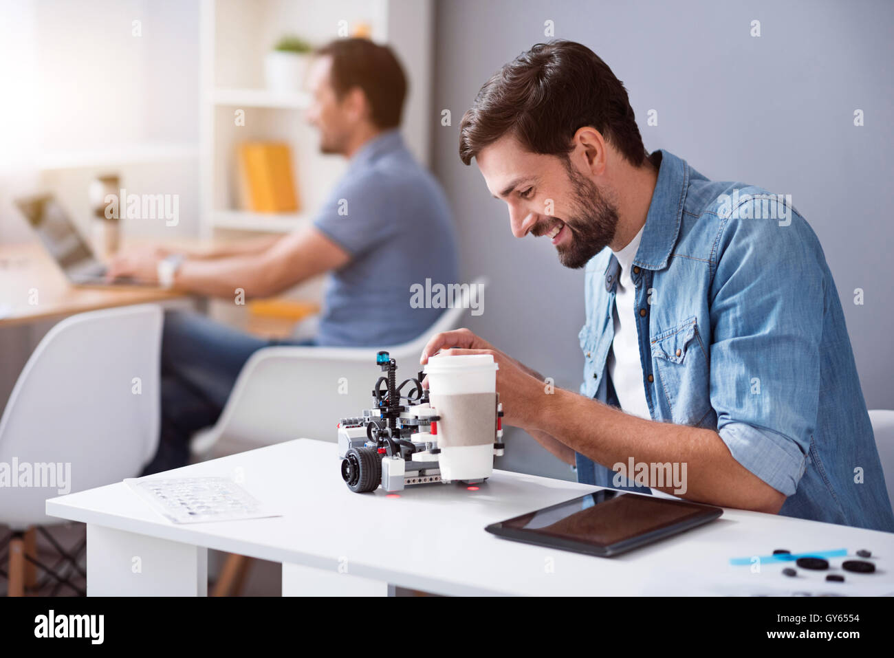 Cheerful man testing robot Stock Photo - Alamy