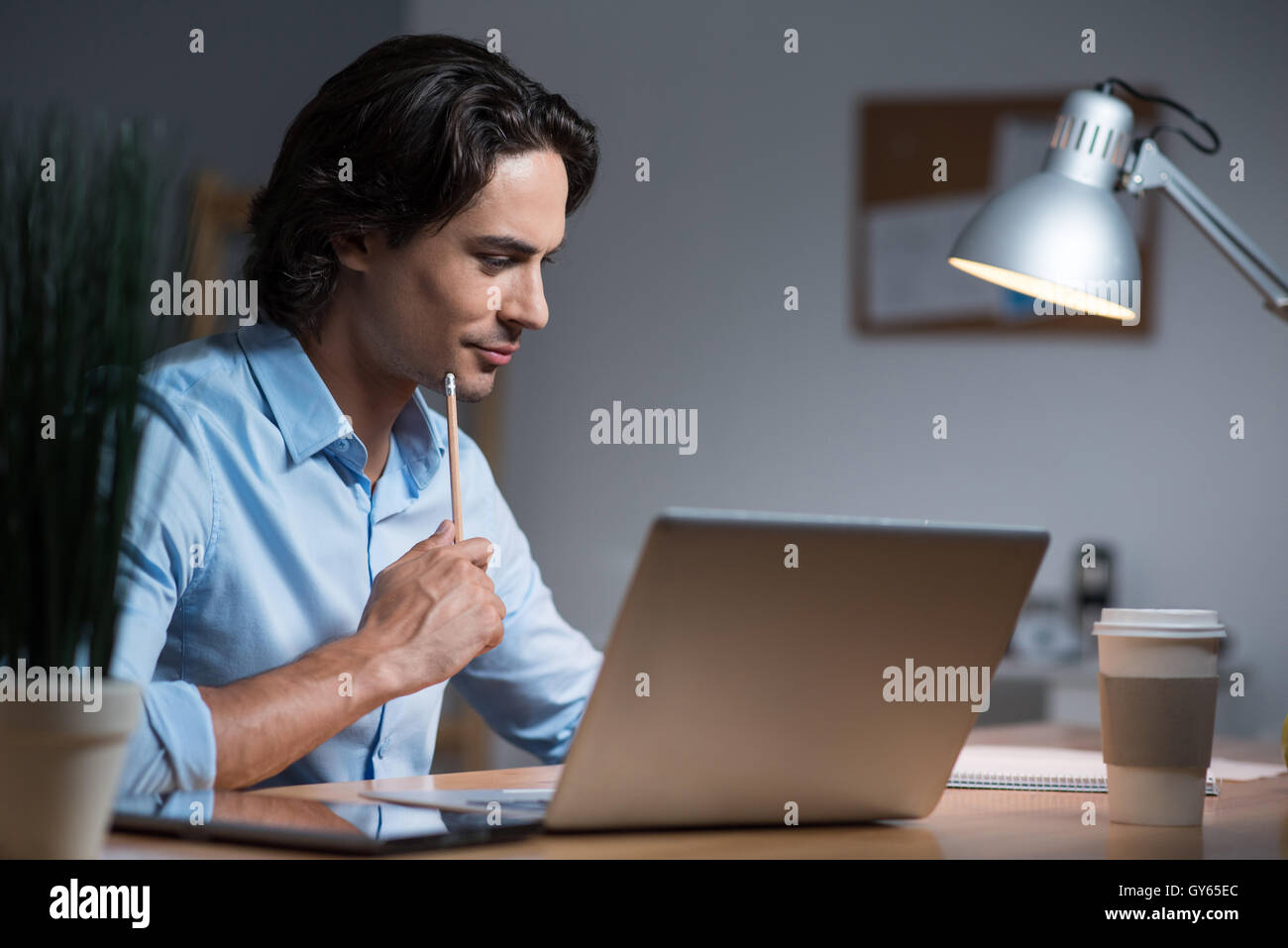 Handsome serious young man using laptop Stock Photo - Alamy