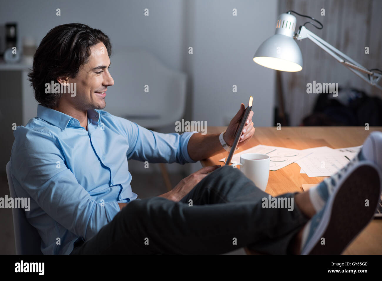 Handsome cheerful yang man using tablet Stock Photo - Alamy