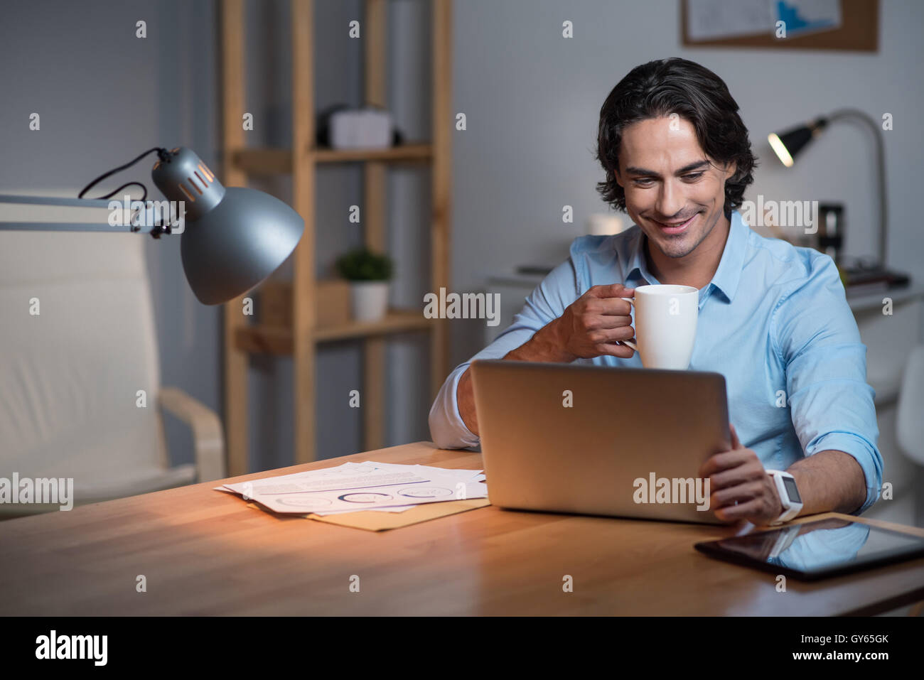 Inspired young good looking man using laptop Stock Photo - Alamy