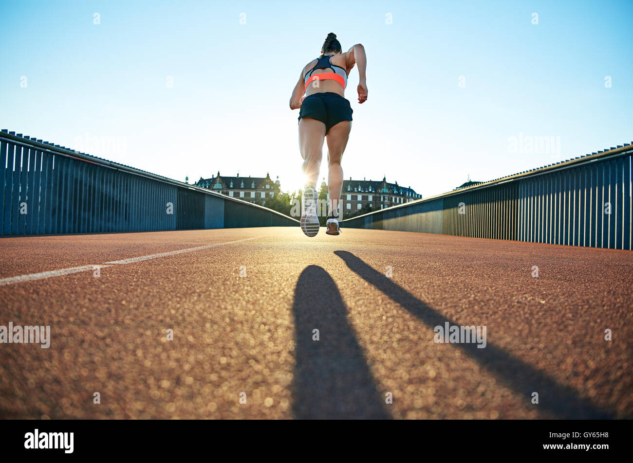 Lean athletic female runner caught mid flight as she sprints towards ...