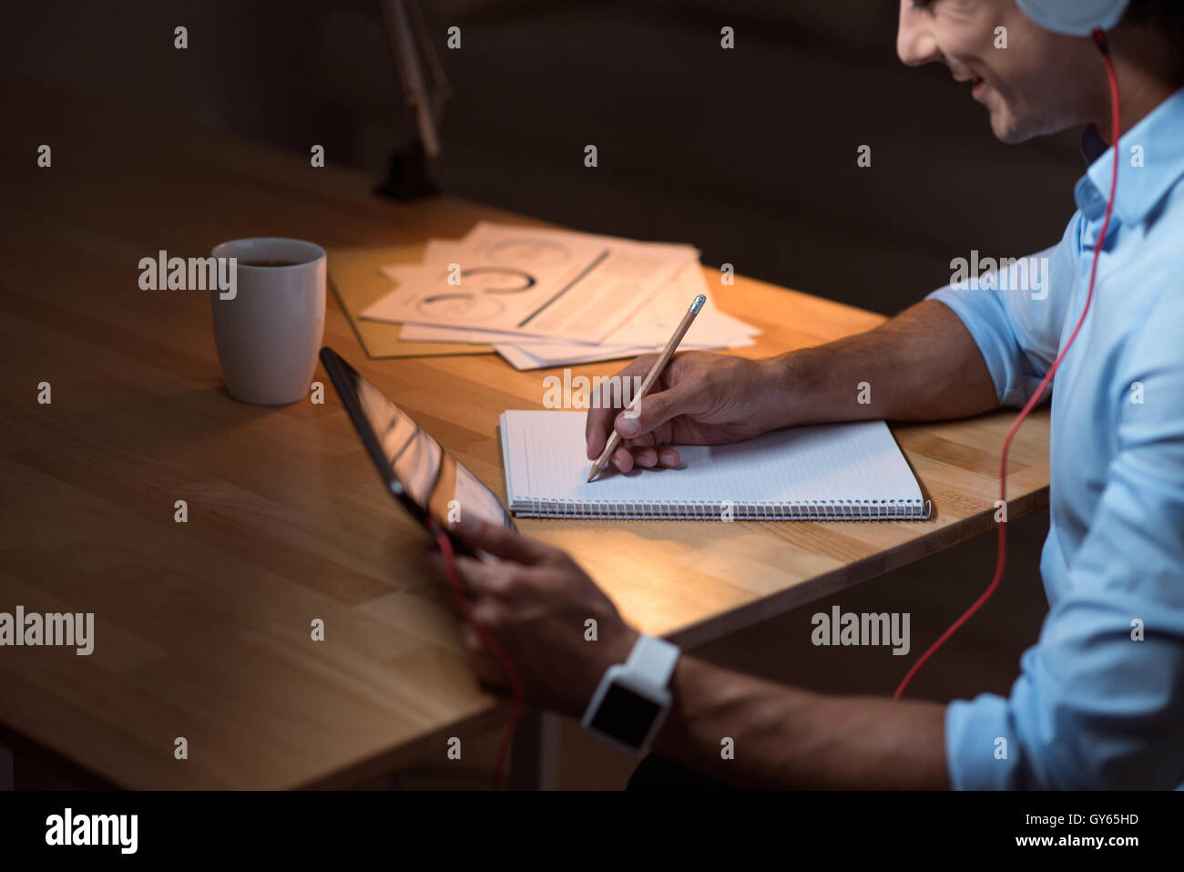 Pleasant smiling man writing on note book Stock Photo - Alamy