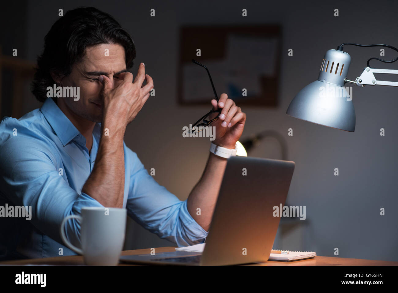 Tired man using the laptop Stock Photo - Alamy