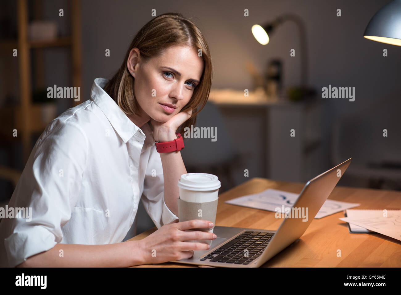 Beautiful woman drinking coffee while working Stock Photo - Alamy
