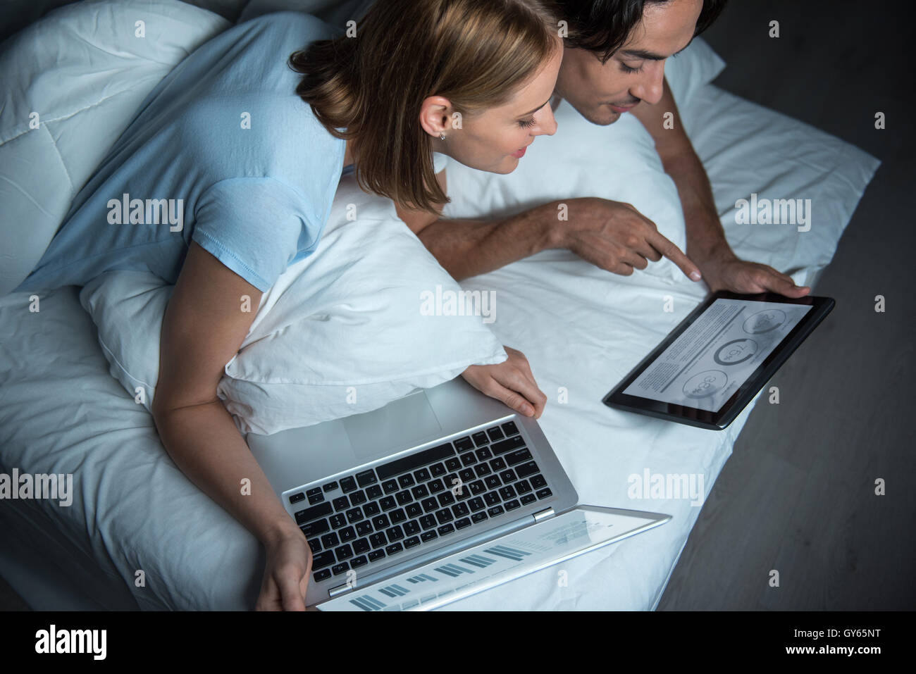 Positive couple resting in bed Stock Photo - Alamy