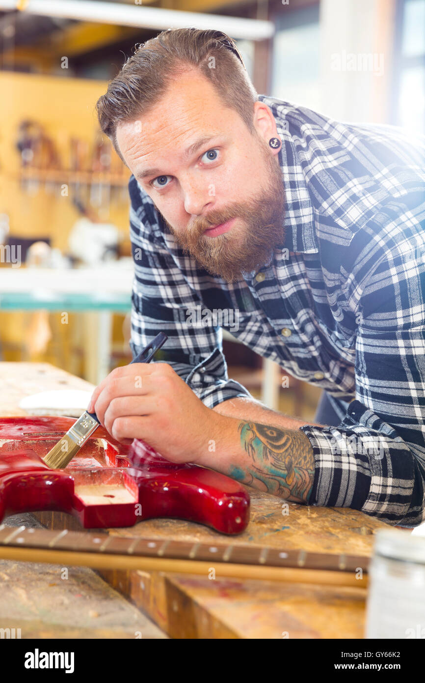 Man working at workshop with musical instruments Stock Photo - Alamy