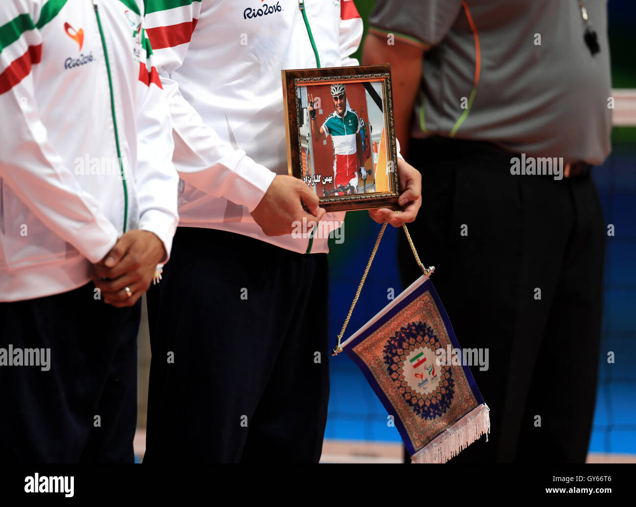 Members of the Iranian team hold up a tribute to cyclist Bahman ...