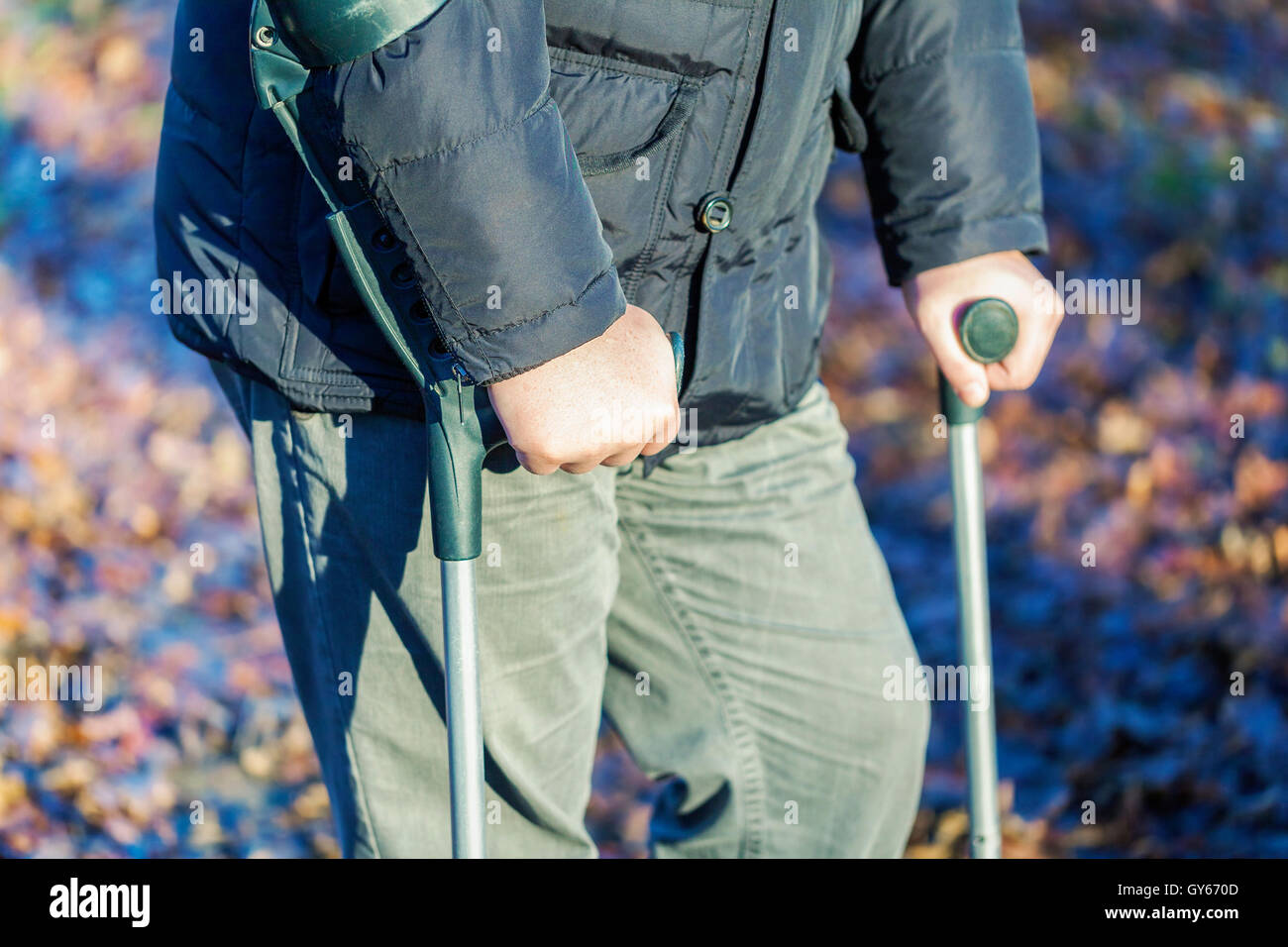 Disabled man on crutches at outdoor Stock Photo - Alamy