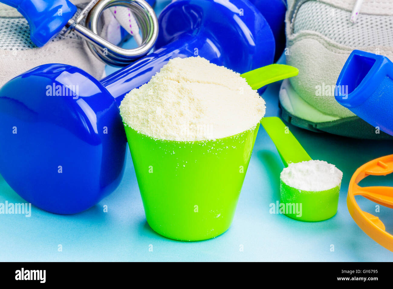 Scoops with whey protein and creatine with sport items around Stock ...