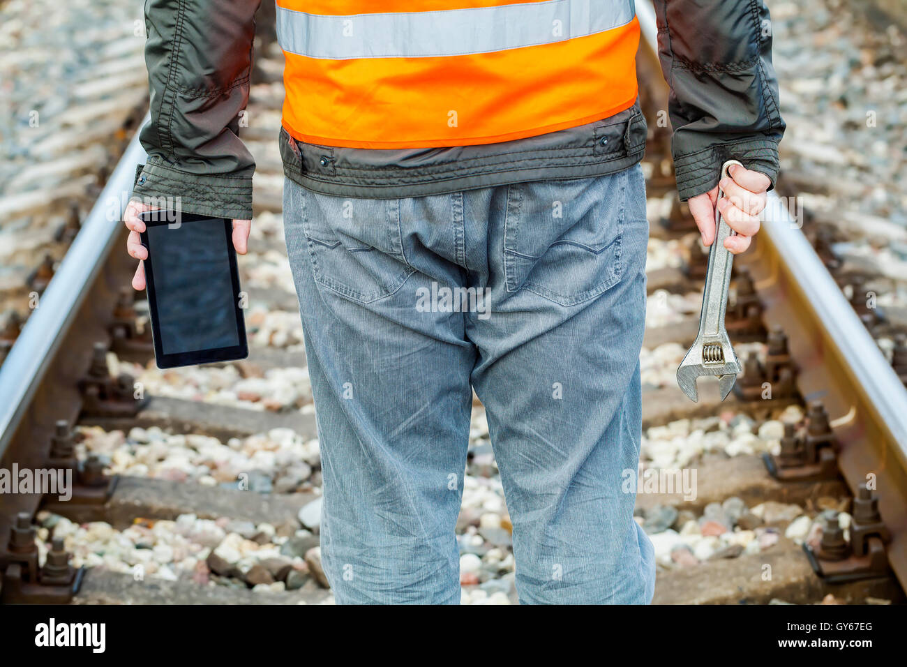 Railway employee with adjustable wrench and tablet PC on railway Stock ...