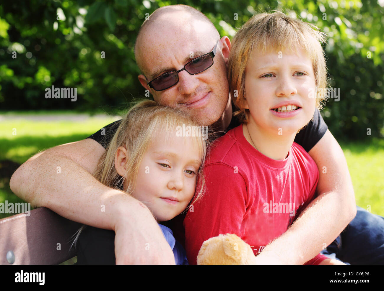 Portrait of father with two kids outdoors Stock Photo - Alamy