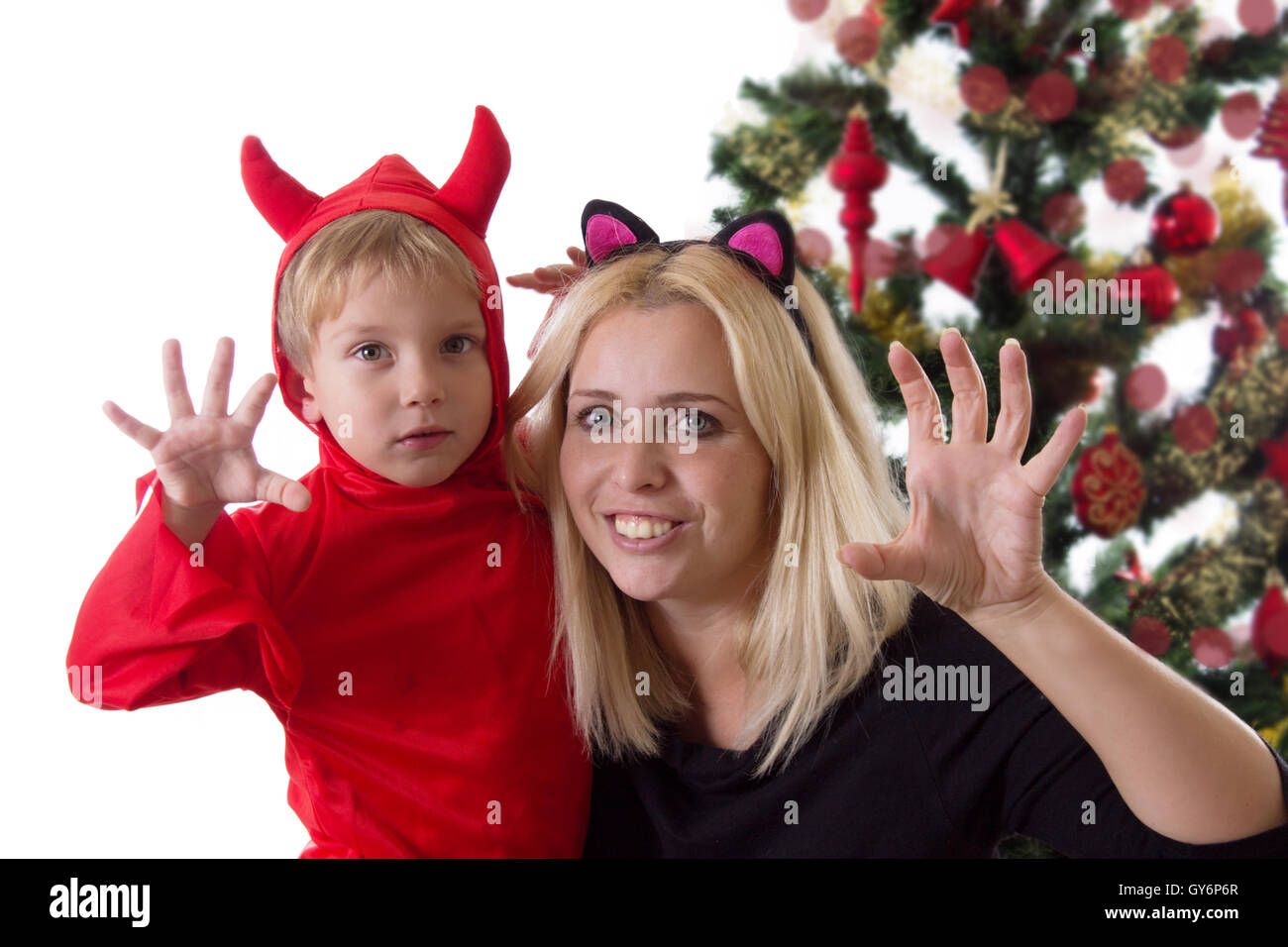 Mother and son in deuce costumes under Christmas tree Stock Photo - Alamy