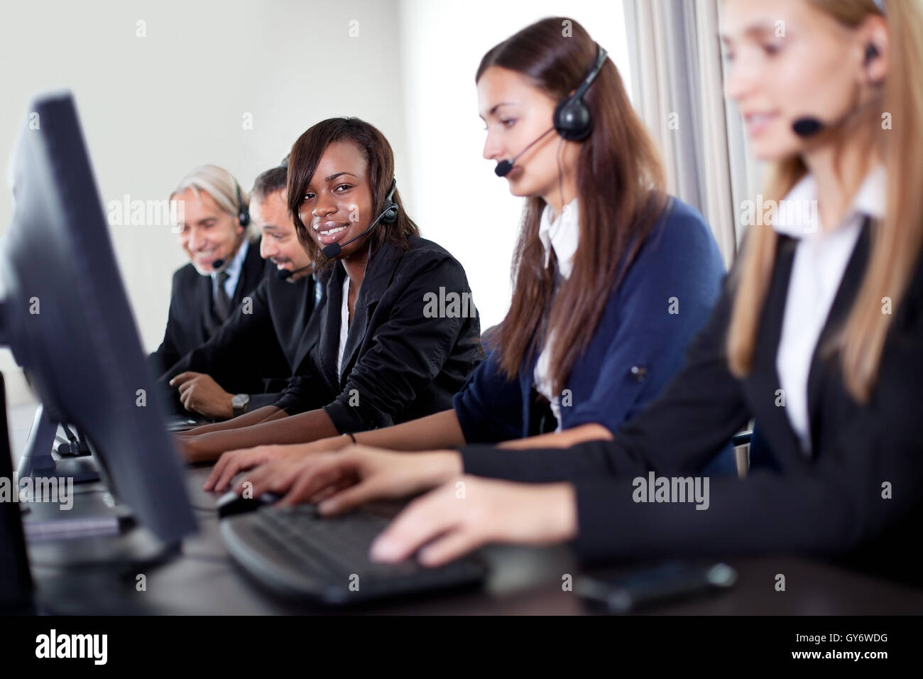 Beautiful customer service woman with her team Stock Photo - Alamy