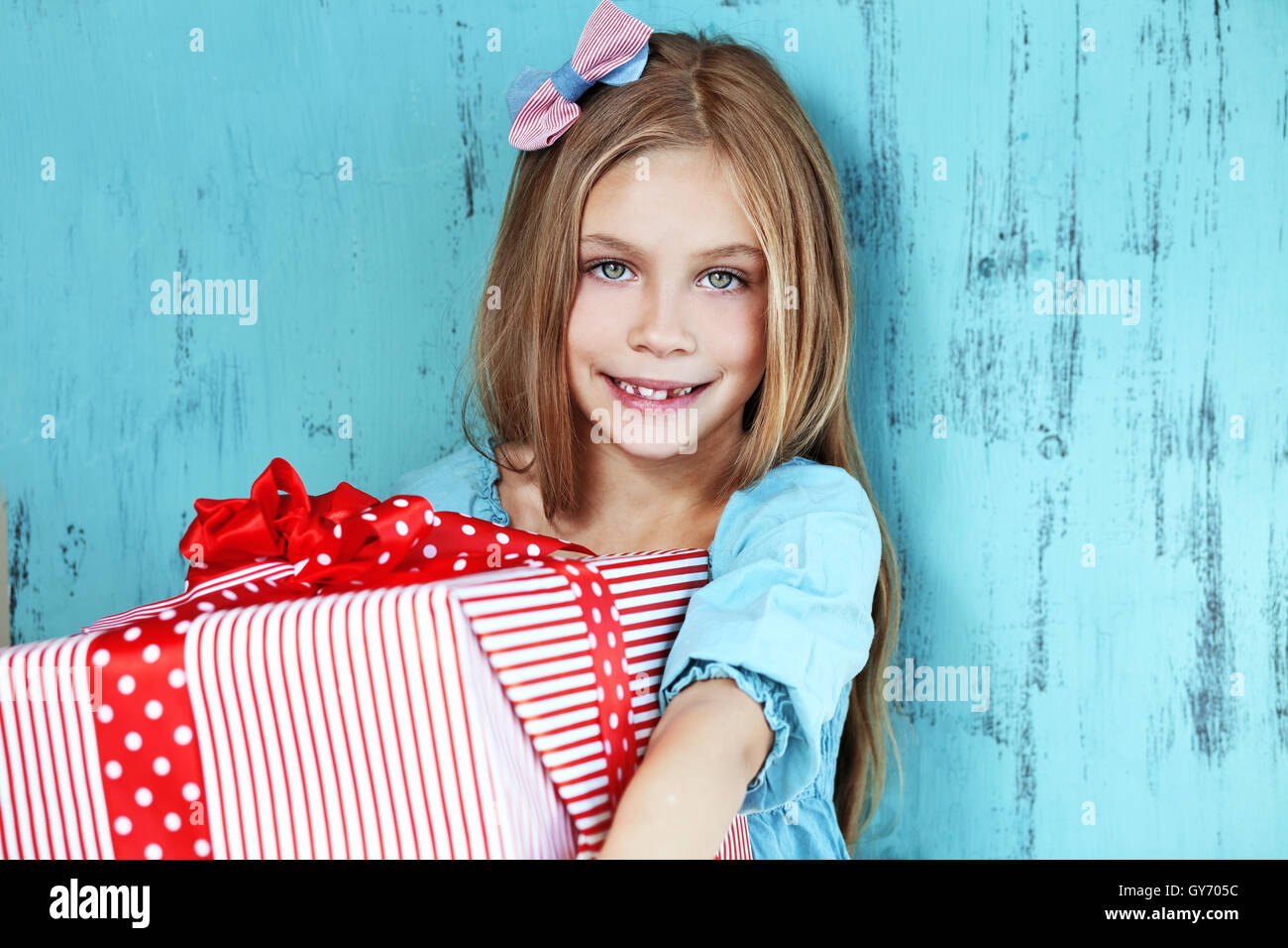 Child holding big gift Stock Photo - Alamy