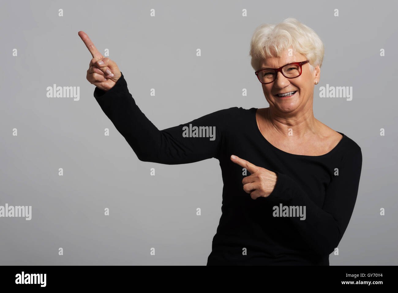 An old happy lady pointing on a copy space Stock Photo - Alamy