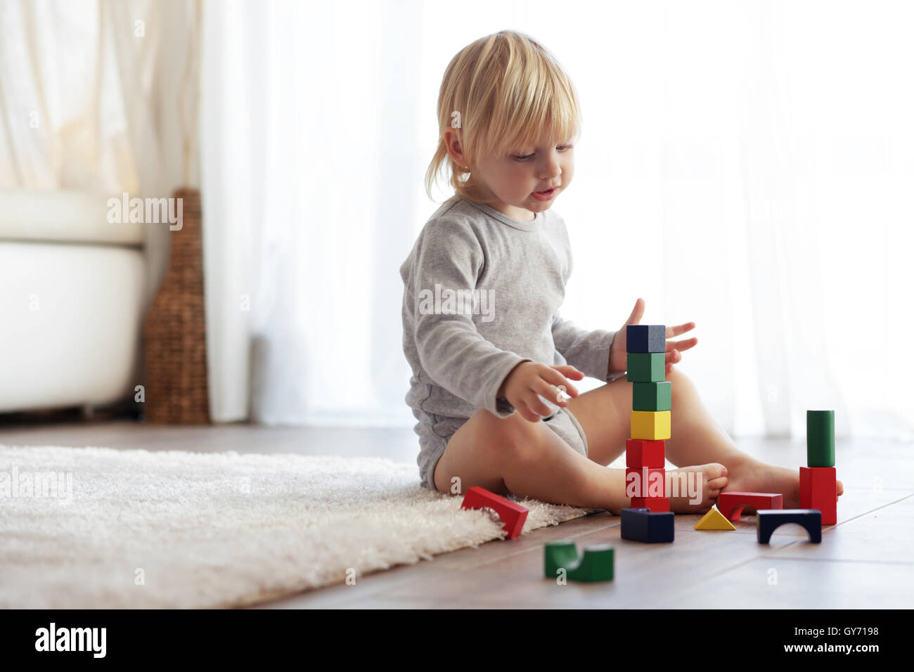 Toddler playing with wooden blocks Stock Photo - Alamy