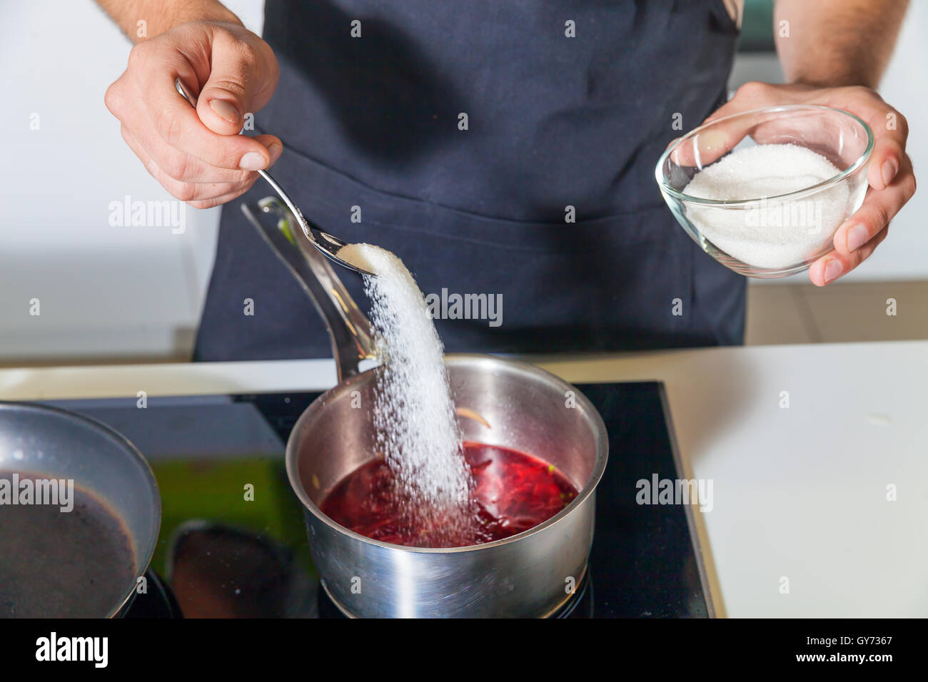 Man sifting sugar in the pan Stock Photo - Alamy