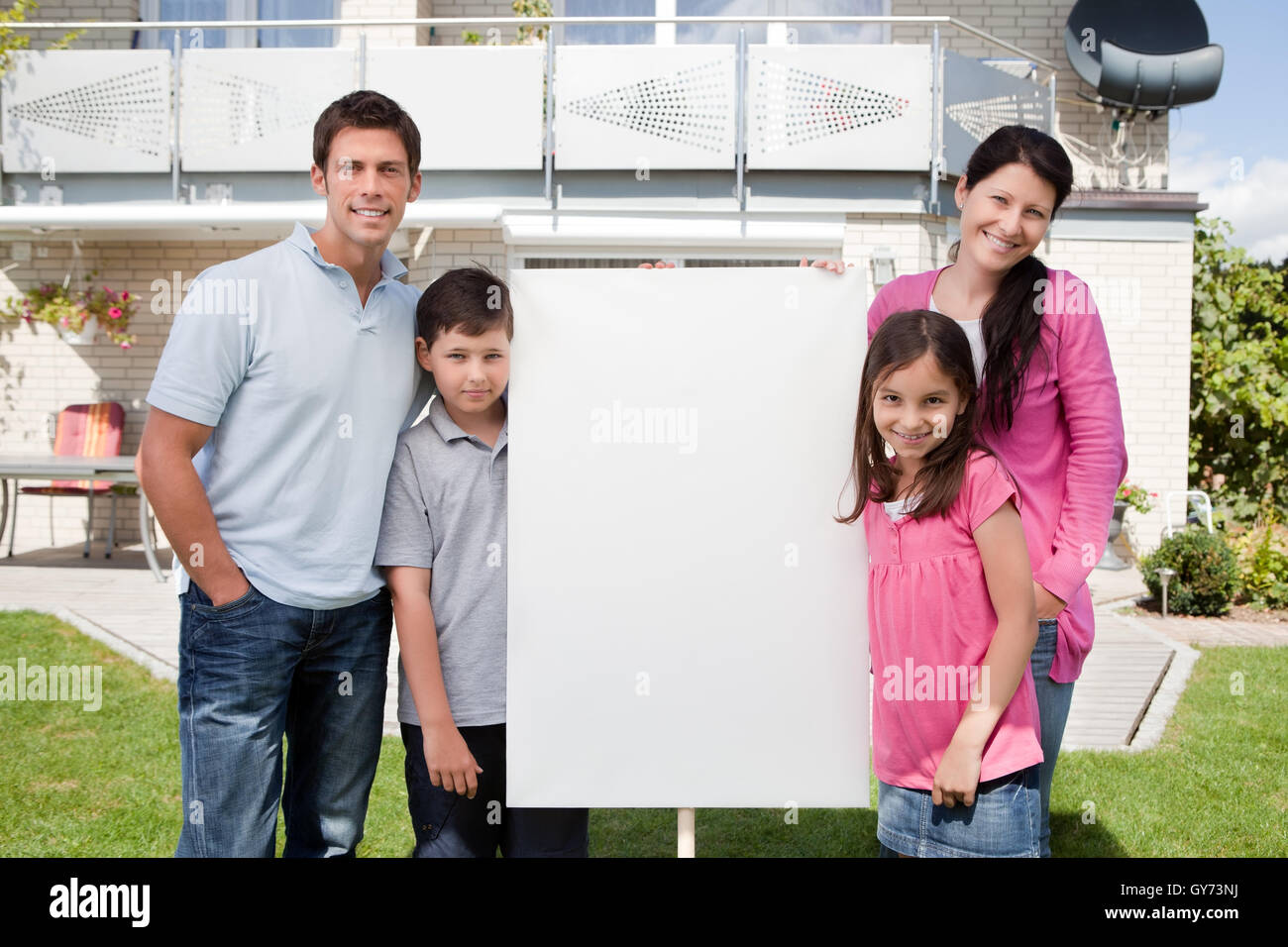 Small family standing outside with a empty sign Stock Photo - Alamy