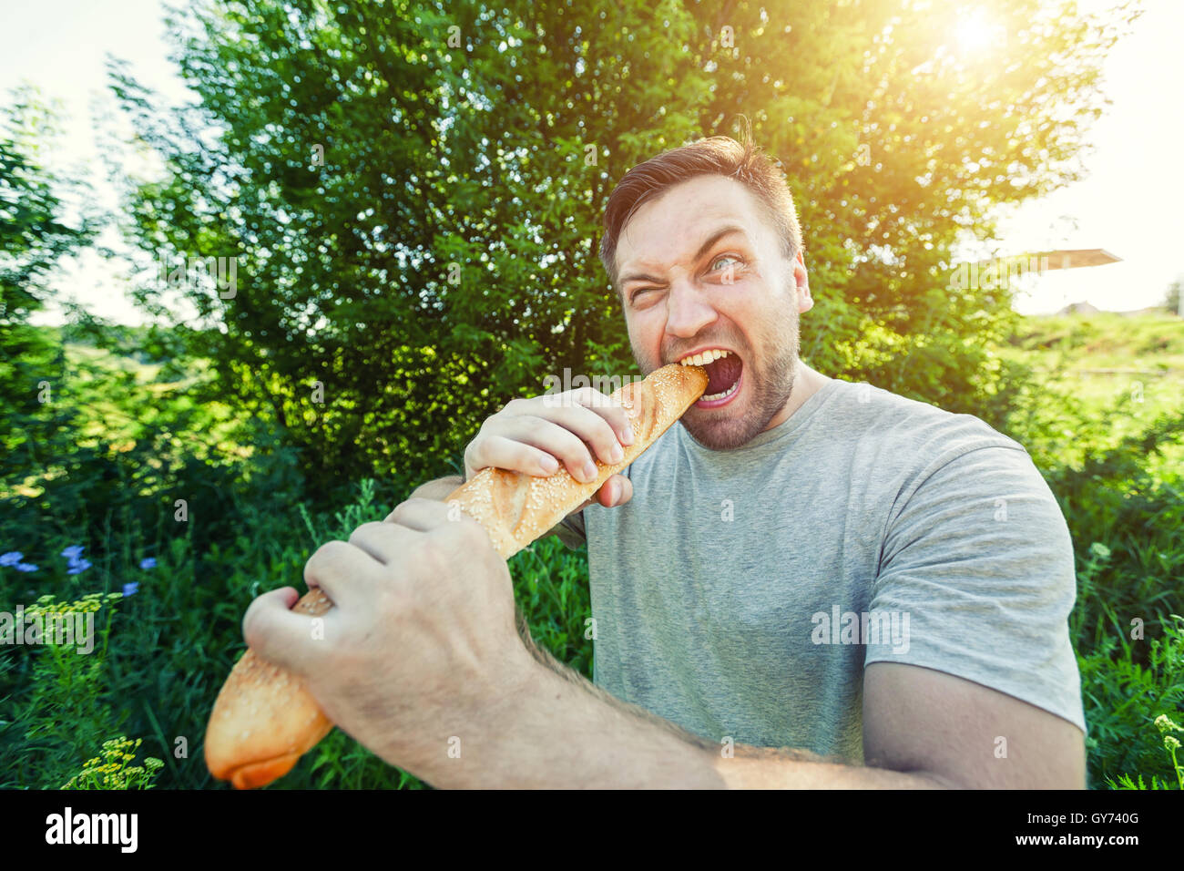 Man eating French bread Stock Photo - Alamy