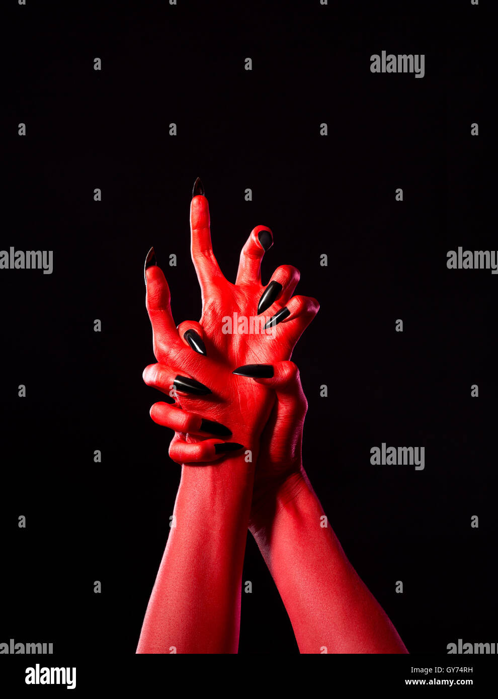 Red demonic hands with black nails, real body-art Stock Photo - Alamy
