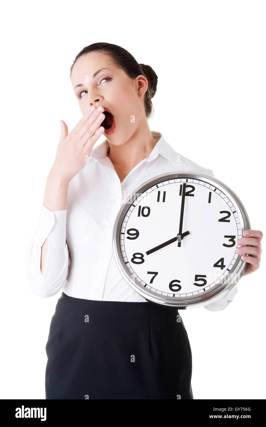 Business woman holding a clock and yeaning Stock Photo - Alamy