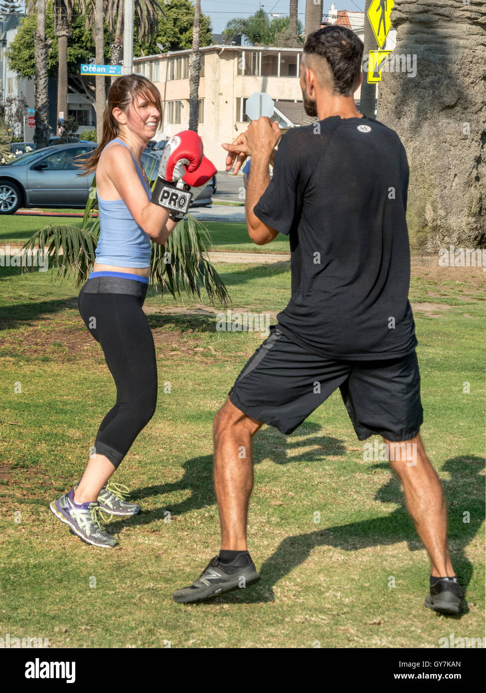 A young woman practices healthy cardio boxing with an instructor ...