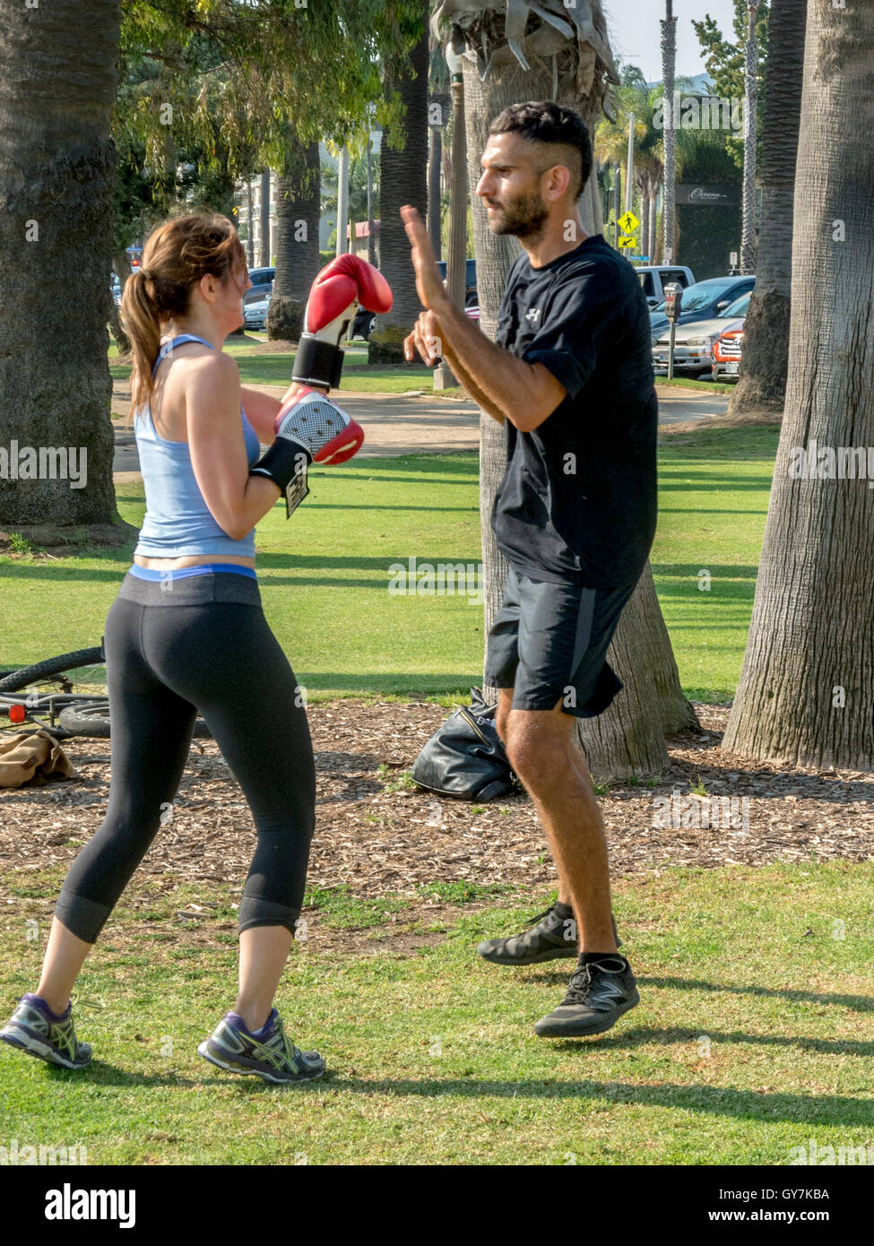 A young woman practices healthy cardio boxing with an instructor ...