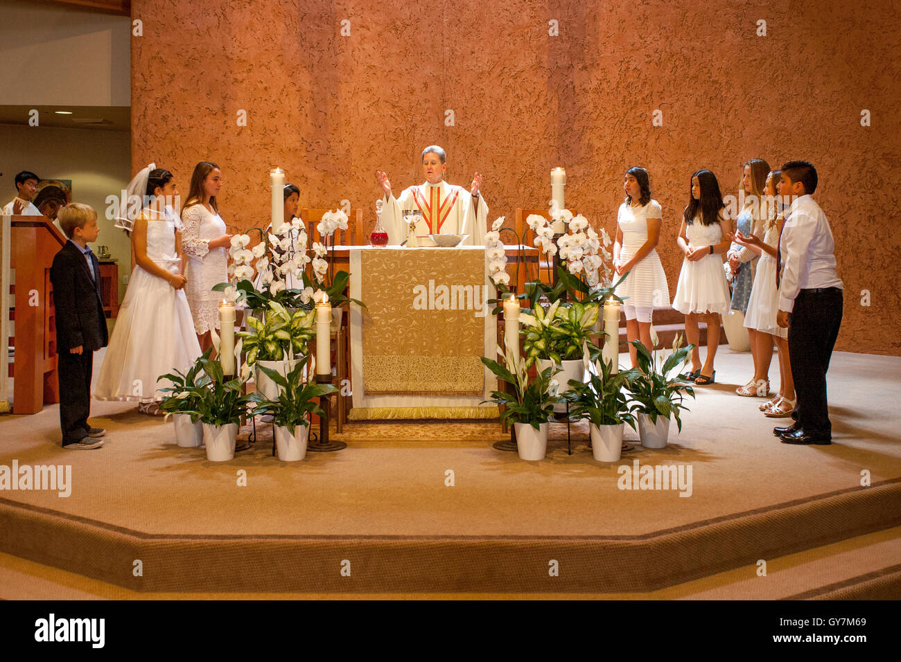 Formally dressed Hispanic and Caucasian children sing a hymn during ...