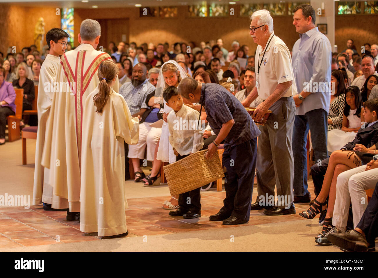Church ushers bring the day's collection in baskets to the monsignor of ...