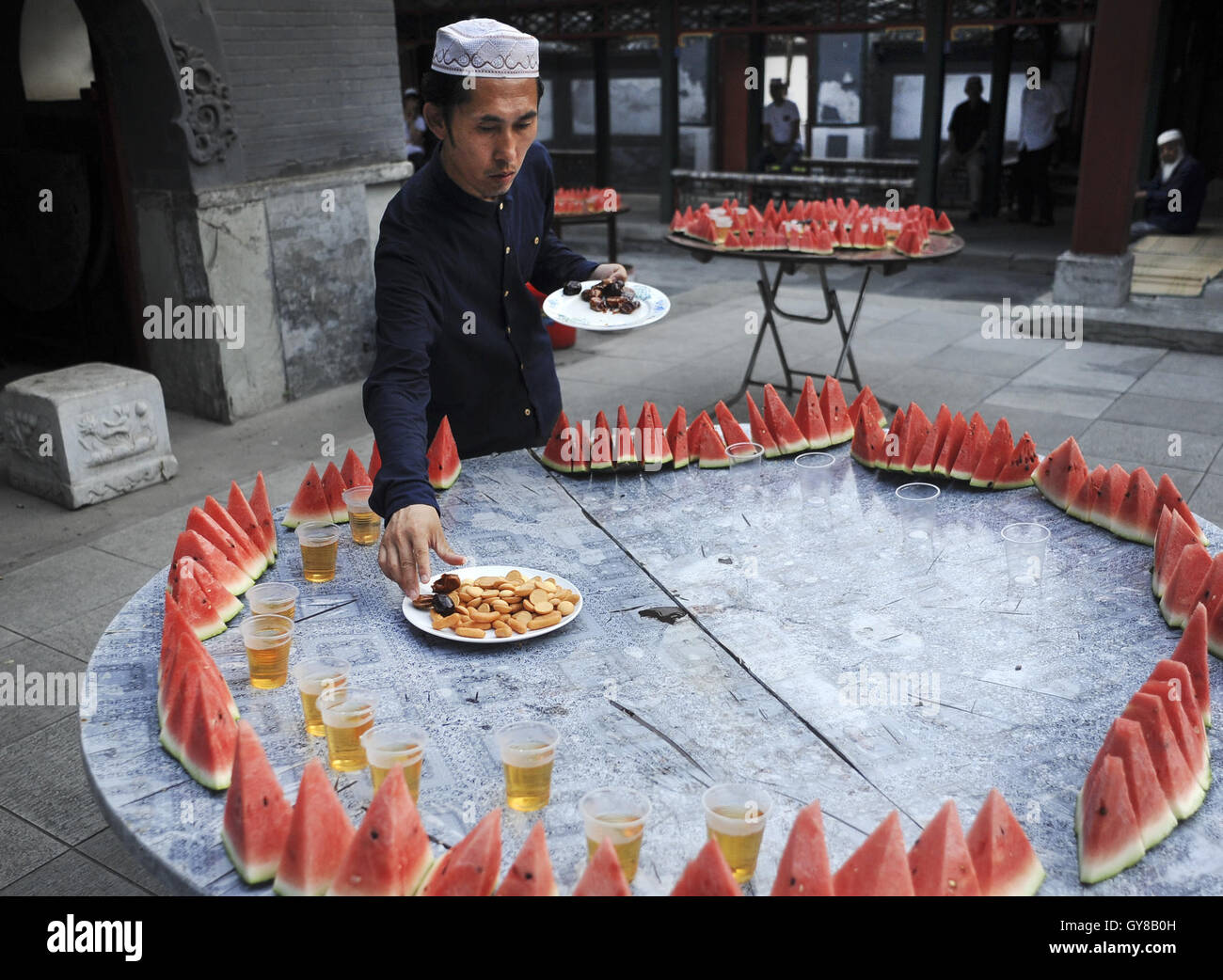 Beijing, China. 25th June, 2016. A man arranges food for people fasting ...