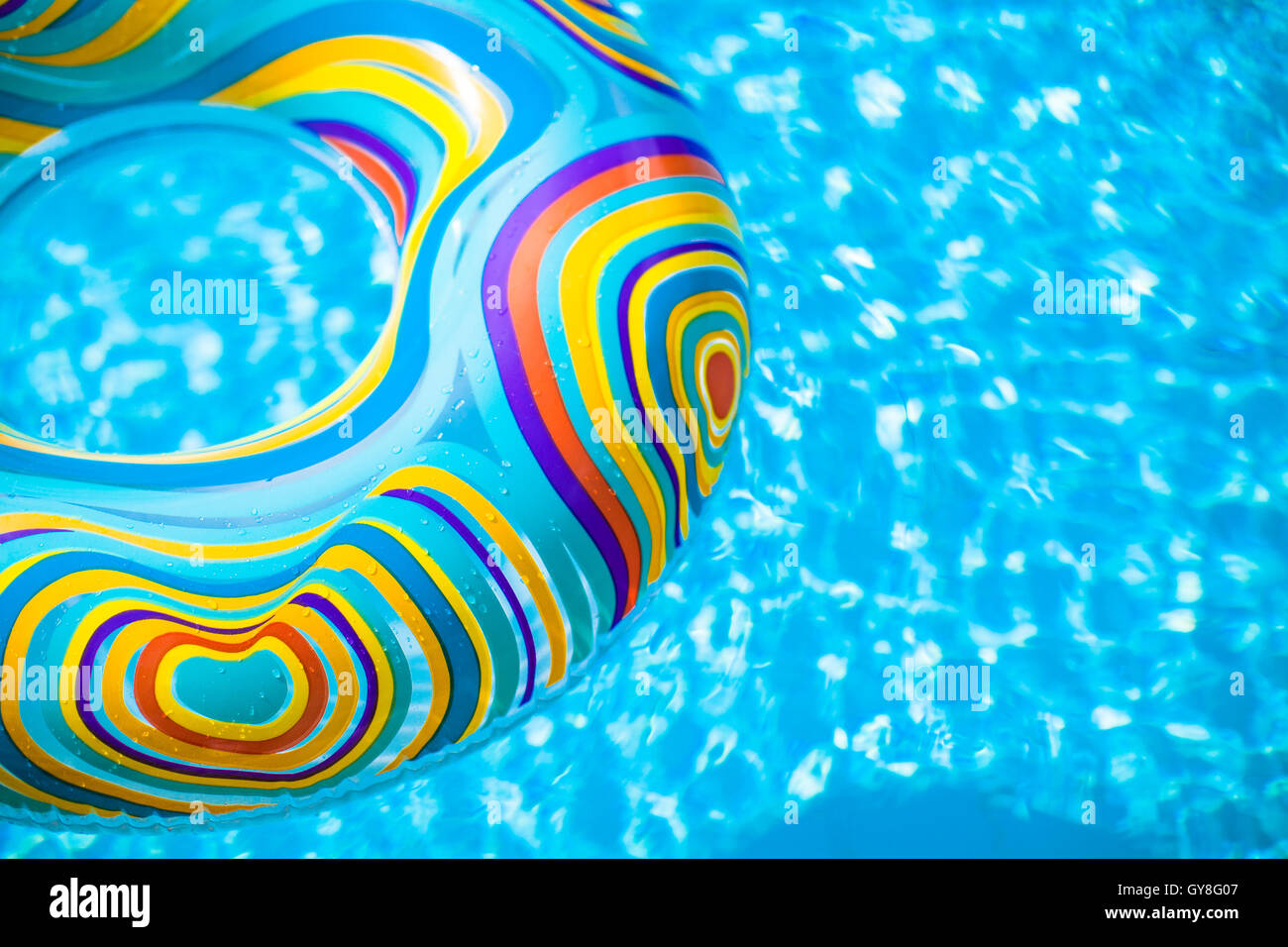 Inflatable colorful Rubber Ring floating in blue swimming pool Stock ...