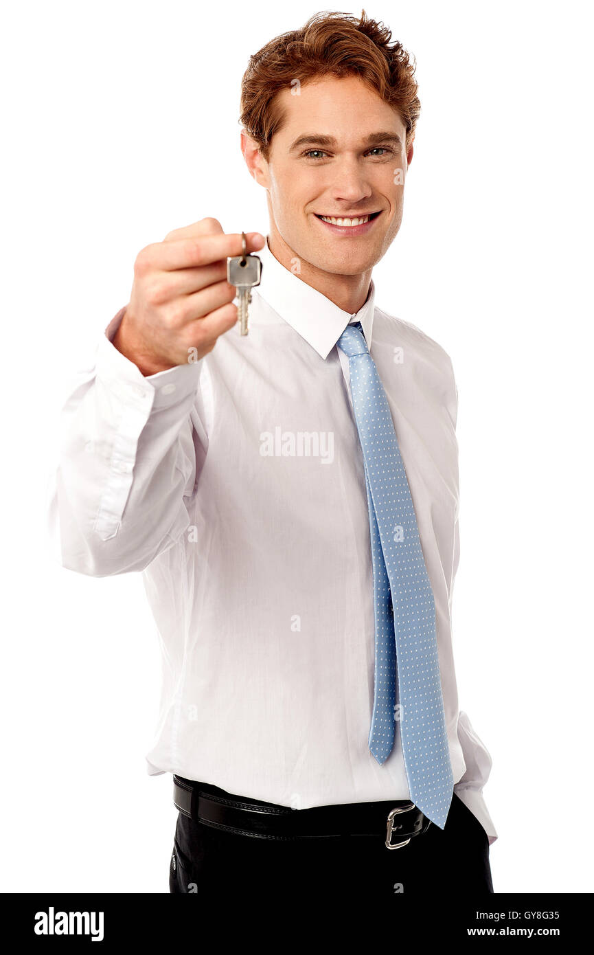 Smiling man offering house key Stock Photo - Alamy