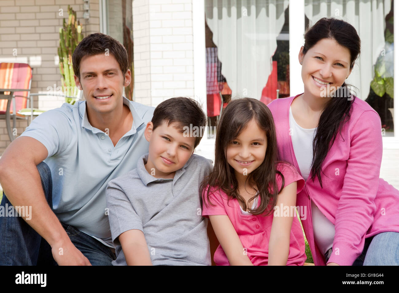Family of four sitting together - Outdoors Stock Photo - Alamy