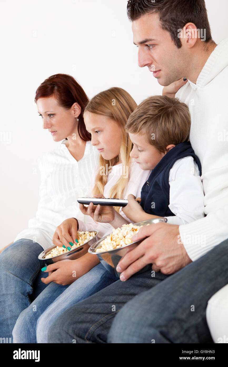 Cheeful young family watching TV at home Stock Photo - Alamy